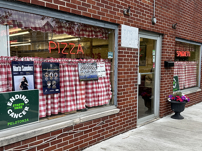 The classic brick exterior with red-checkered curtains and neon signs isn't trying to be trendy&mdash;it's the real deal, a time capsule of authentic Italian-American dining.