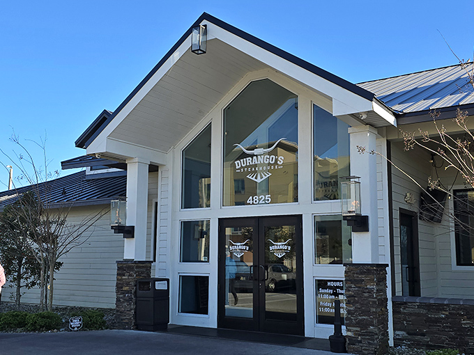 The modern farmhouse exterior hints at the Western charm waiting inside, where steaks take center stage over architectural showboating.