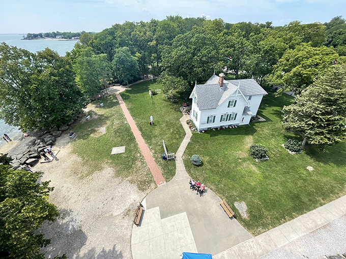 A bird's-eye view of paradise where the keeper's house stands sentinel, surrounded by emerald lawns and Lake Erie's endless blue horizon.