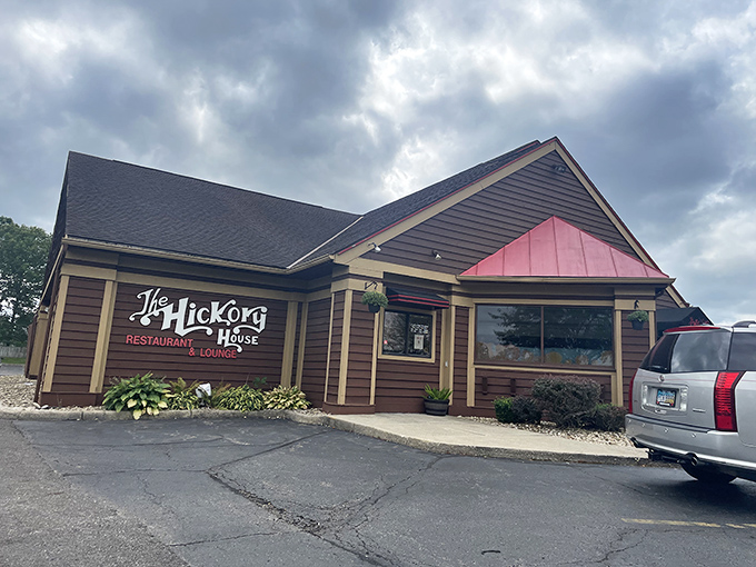 The iconic red sign of Hickory House glows at dusk, a beacon for hungry travelers promising BBQ ribs, steaks, and a Reynoldsburg tradition since 1979.