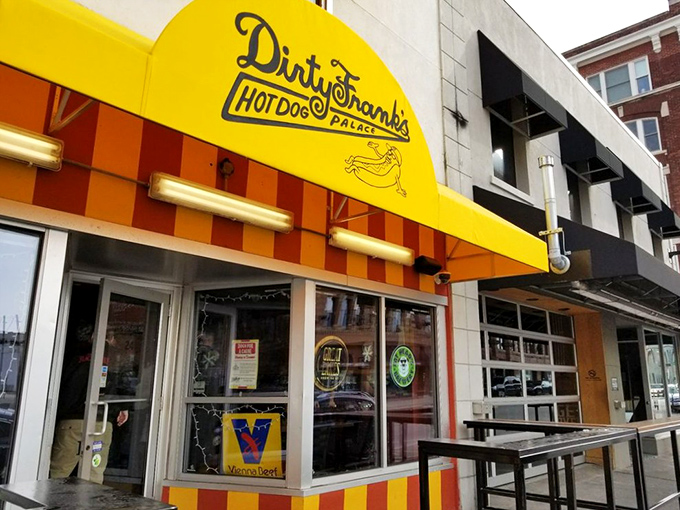 The bright yellow awning of Dirty Frank's Hot Dog Palace beckons hungry visitors like a culinary lighthouse in downtown Columbus. Hot dog heaven awaits!