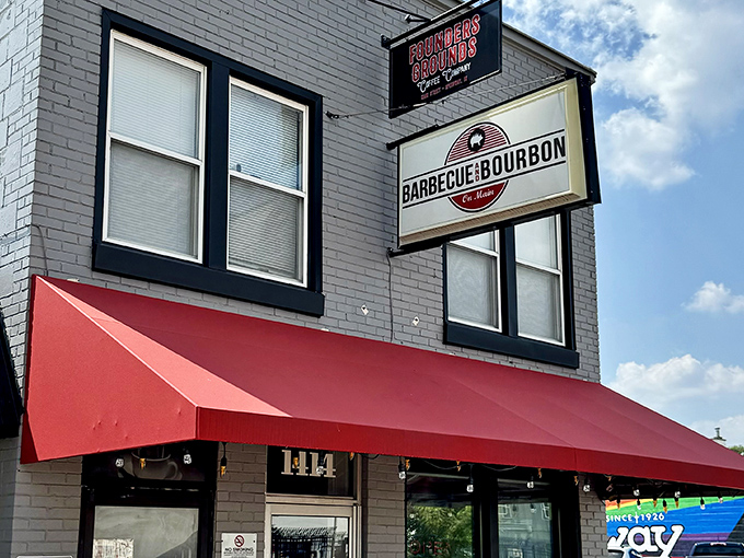 The bright red awning against the gray brick facade isn't just eye-catching&mdash;it's a beacon for barbecue pilgrims seeking smoky salvation in Speedway.