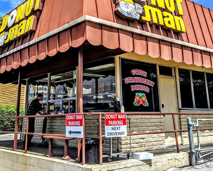 The iconic orange-brown awning of The Donut Man stands as a beacon of sweetness on Route 66, where pilgrims of pastry make their delicious hajj.