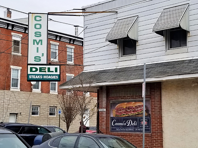 The iconic green and white Cosmi's sign stands like a beacon of sandwich salvation on this South Philly corner. Cheesesteak paradise awaits!