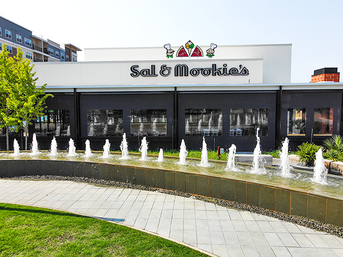 The welcoming facade of Sal & Mookie's, where dancing fountains set the stage for the pizza paradise waiting inside.