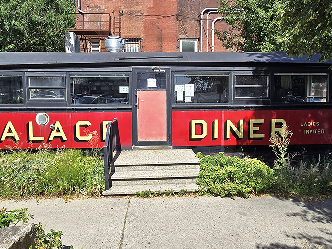 The iconic red exterior of Palace Diner beckons food pilgrims to Biddeford's time-traveling culinary treasure housed in a vintage rail car.