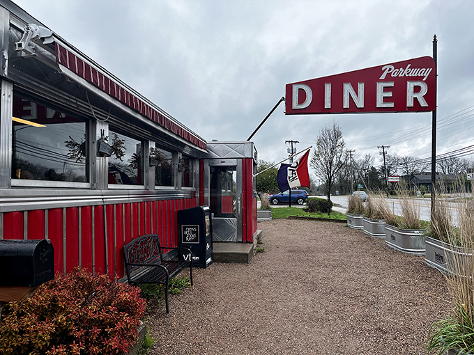 The classic red and silver exterior of Parkway Diner stands like a time capsule against Vermont's blue sky, beckoning hungry travelers with retro charm.