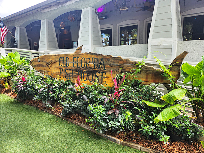 The iconic fish-shaped sign welcomes you like an old friend. Lush tropical plants frame this wooden masterpiece, promising seafood adventures ahead.