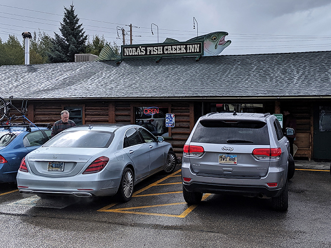 The unassuming log cabin exterior of Nora's Fish Creek Inn proves that culinary treasures often hide in plain sight. That fish on the sign? Consider it your breakfast spirit guide.