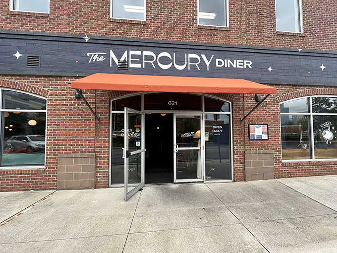 The Mercury Diner's brick facade with its distinctive navy blue signage and orange awning beckons like a retro-futuristic beacon on Columbus's streetscape.
