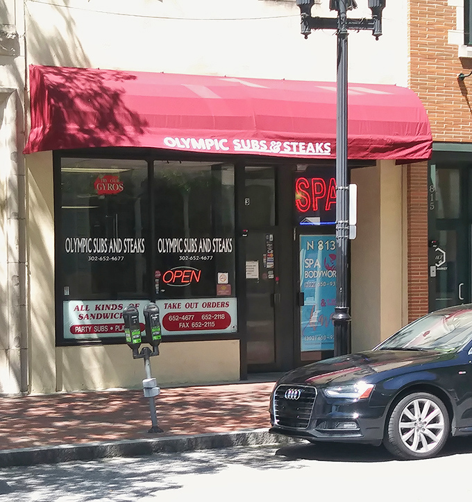 The iconic red awning of Olympic Subs & Steaks stands out like a beacon for sandwich lovers. No fancy frills, just the promise of Delaware's finest cheesesteaks inside.
