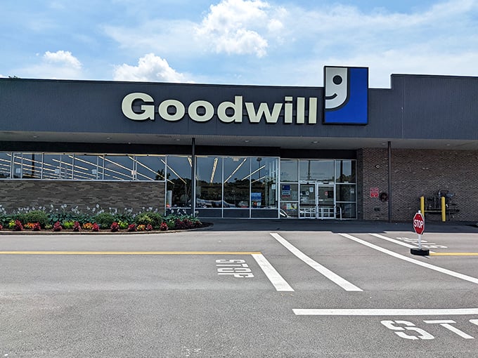 The blue and white Goodwill sign beckons like a lighthouse for bargain hunters, promising treasures within that won't break the bank.