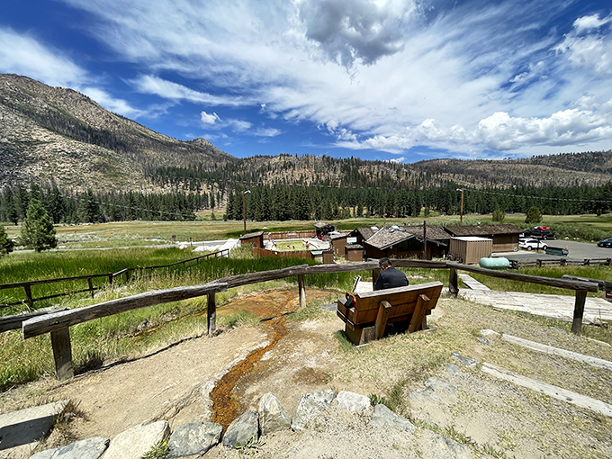 Nature's grandstand: Sierra peaks frame the rustic hot springs complex like they're showing off for visitors. Mother Nature's version of theater-in-the-round.