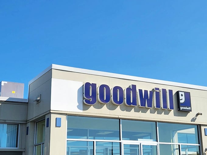 The iconic blue Goodwill sign against a clear sky &ndash; retail therapy with a conscience and prices that'll make your wallet smile.