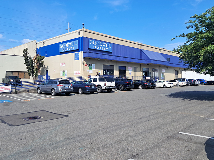 The blue-trimmed exterior of Seattle Goodwill beckons like a retail oasis in the urban landscape, promising treasures for those brave enough to venture inside.