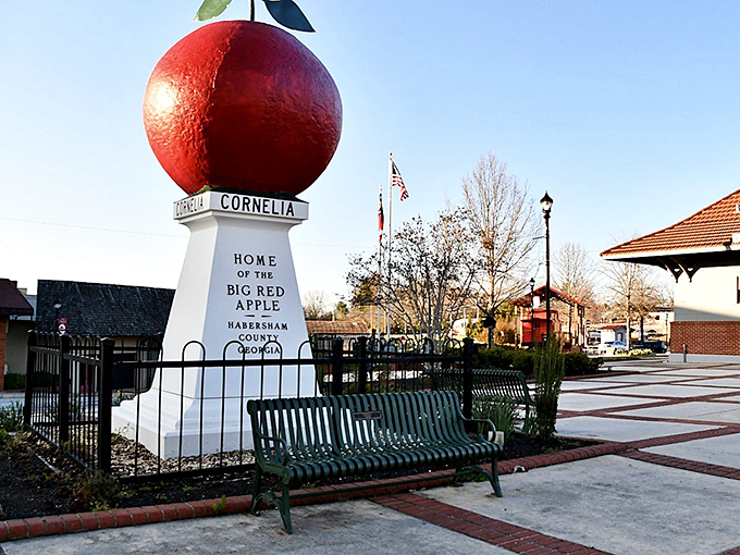 The Big Red Apple stands proudly against the blue Georgia sky, a crimson beacon of small-town charm that's impossible to miss.