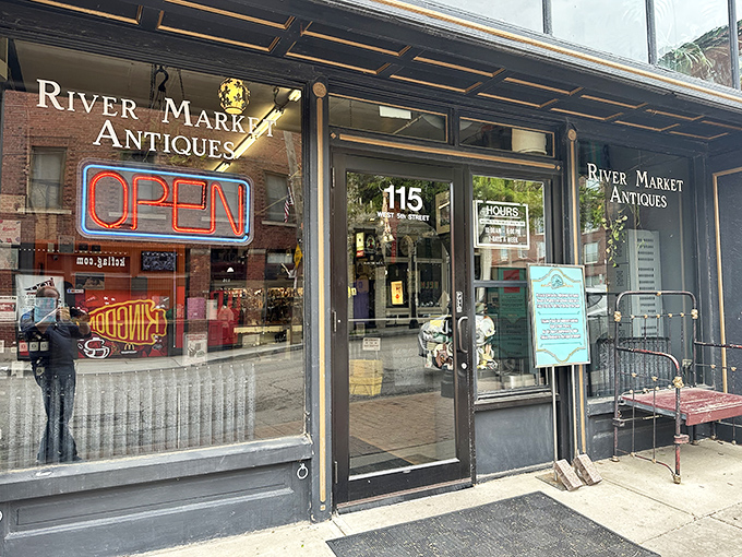 The iconic storefront of River Market Antiques beckons with its glowing neon "OPEN" sign &ndash; a portal to treasures waiting to be discovered inside this Kansas City landmark.