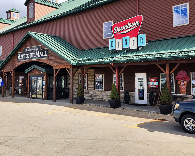 The barn-like exterior of Berlin Village Antique Mall promises treasures within, while that Downtown Diner sign whispers sweet nothings about post-antiquing sustenance.