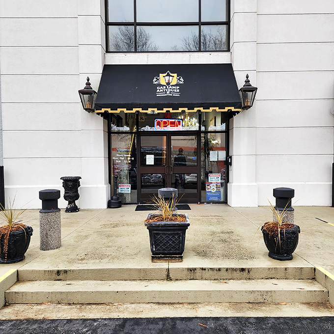 The elegant entrance to GasLamp Antiques beckons with classic black awning and vintage lanterns&mdash;like a sophisticated time portal waiting to be opened.