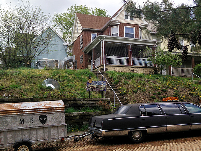 The unassuming exterior of Trundle Manor hides its bizarre treasures, with a vintage hearse parked outside like the family sedan.