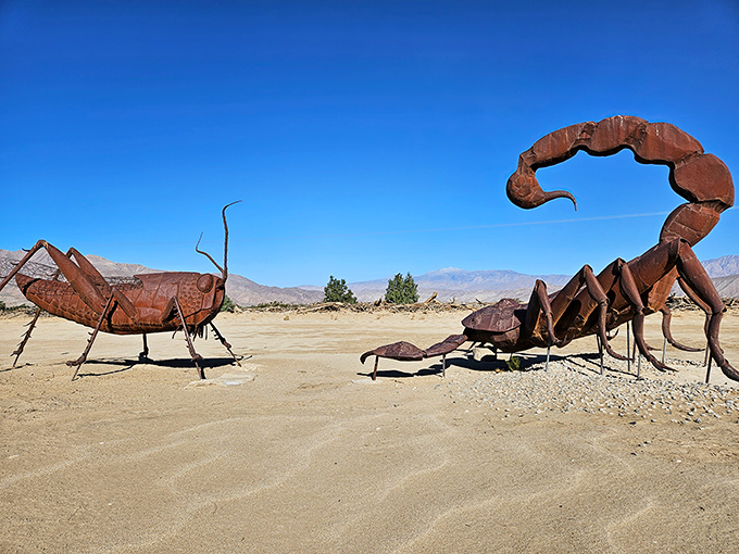 In the heart of the California desert, a giant scorpion faces off against a towering grasshopper &mdash; a surreal standoff frozen in rust and sunlight.