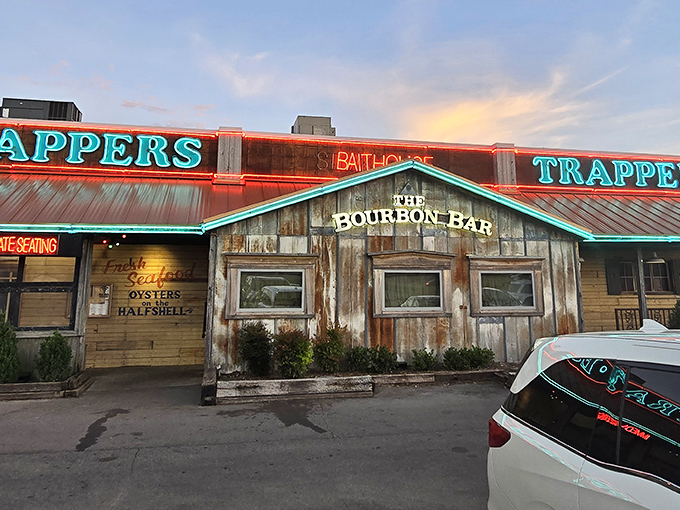 Sunset paints the sky as Trapper's neon signs flicker to life. The weathered wood exterior promises authentic rustic charm that matches the seafood treasures within.