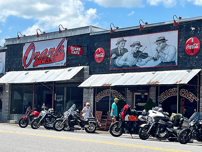 The iconic facade of Ozark Cafe welcomes hungry travelers with its vintage musicians mural and classic rocking chairs &ndash; a roadside beacon for food pilgrims.