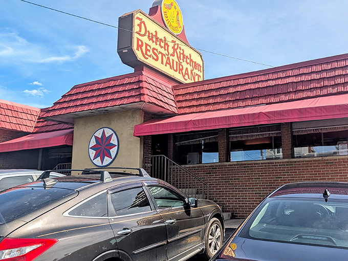 The iconic red-roofed Dutch Kitchen stands like a culinary lighthouse, its vintage sign and traditional hex star promising comfort food salvation for weary travelers.