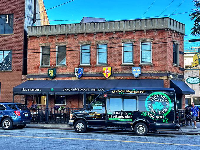 The brick facade of Cleveland's oldest Irish pub stands proudly in the Flats, its triangular shape and heraldic shields promising authentic experiences inside.