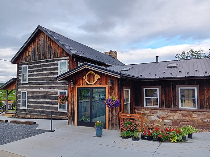 The rustic log cabin exterior of Horn O' Plenty welcomes you like an old friend, complete with colorful flower baskets that say "come on in, the pizza's waiting."