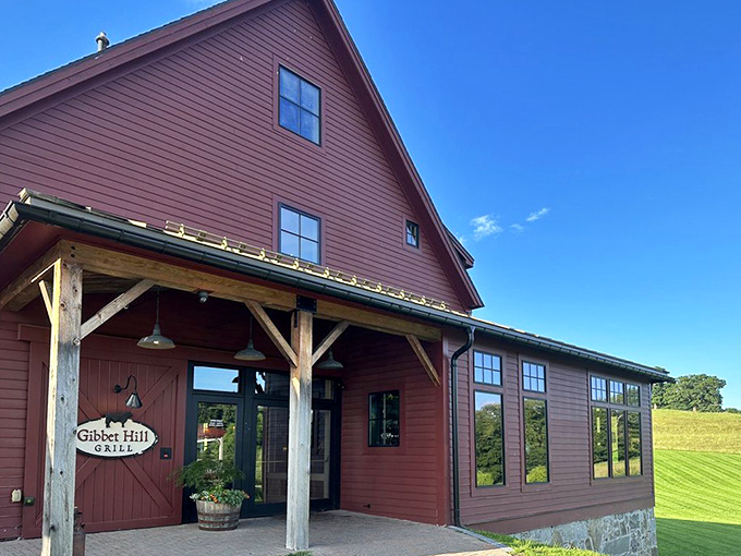 The iconic red barn exterior of Gibbet Hill Grill stands proudly against rolling Massachusetts countryside&mdash;farm-to-table dining in its most literal form.