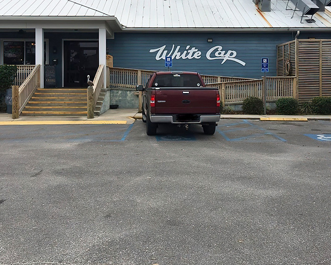 The blue exterior of White Cap welcomes seafood lovers like a maritime beacon. Those yellow steps practically shout "fresh catch ahead!"