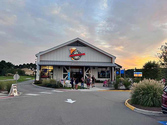Sunset magic at Shorebreak Pizza & Taphouse, where the Pungo countryside meets coastal cuisine. The white farmhouse exterior promises comfort before you even step inside.