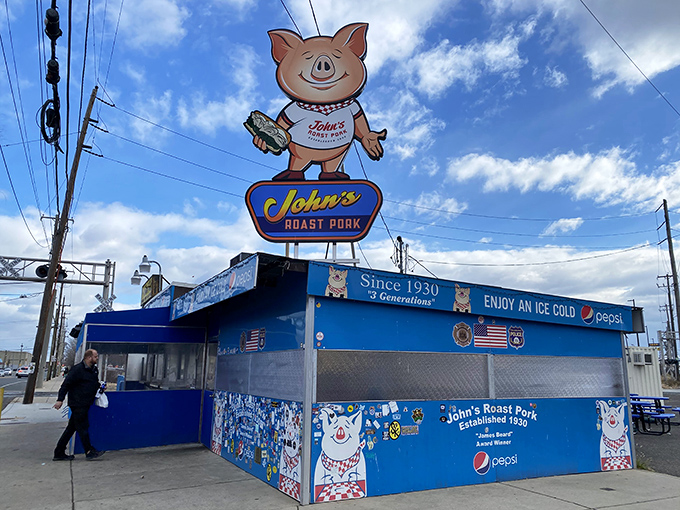 The iconic cartoon pig sign stands proudly above John's Roast Pork, a blue sandwich sanctuary that's been calling Philadelphians home since 1930.