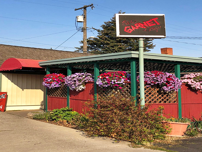 The Garnet Cafe's exterior blooms with hanging flower baskets, a colorful welcome that hints at the vibrant flavors waiting inside this unassuming breakfast paradise.