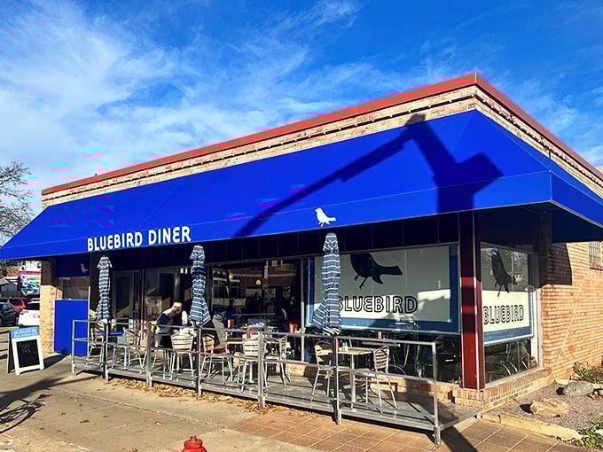 The iconic blue awning of Bluebird Diner stands out like a superhero cape against Iowa City's skyline, promising breakfast adventures within.