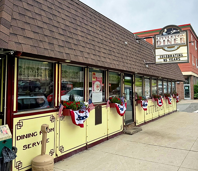 The Littleton Diner's cheerful yellow exterior welcomes hungry travelers like a beacon of breakfast hope on Main Street.