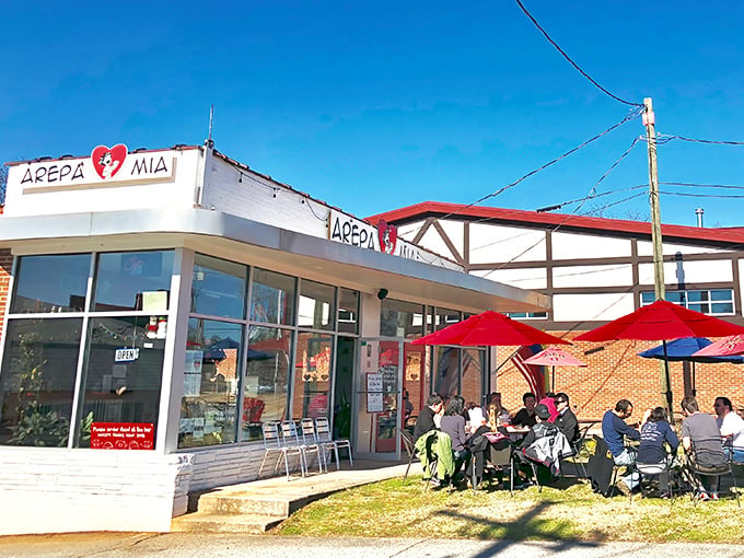 Venezuelan paradise found! Arepa Mia's vibrant outdoor seating area beckons with metal chairs under rustic wooden beams&mdash;an irresistible invitation to culinary adventure.