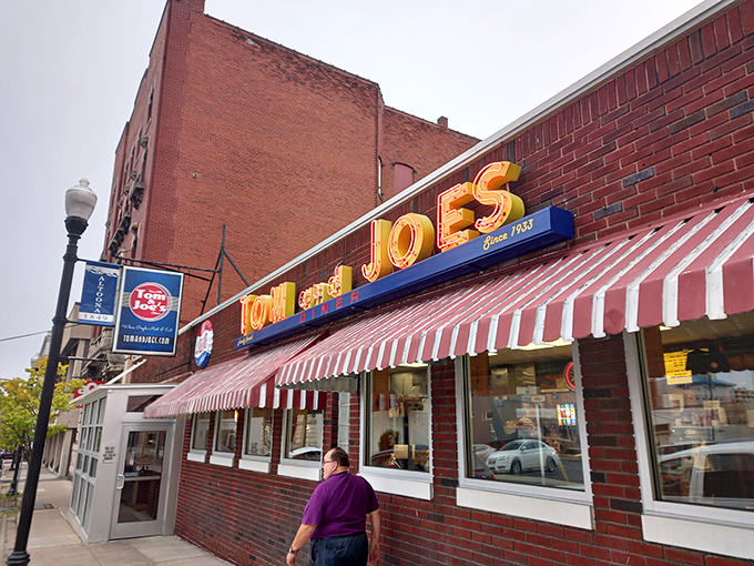 The iconic red and white awning of Tom & Joe's beckons hungry travelers like a lighthouse for breakfast enthusiasts. Classic neon signage promises timeless comfort within.