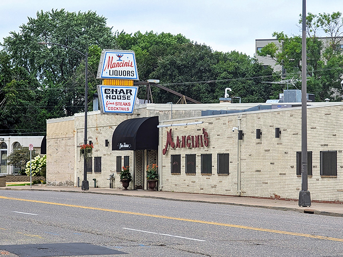 Mancini's white brick exterior stands proudly on West 7th, its vintage sign promising the kind of dining experience where memories are made and calories are gloriously ignored.