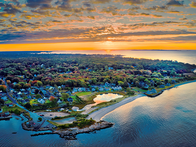 Sunset paints the sky in Waterford, where tree-lined neighborhoods meet sandy shores in perfect New England harmony.