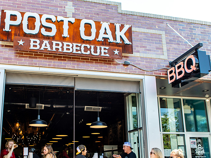 The rusted patina of Post Oak's sign isn't just for show&mdash;it's a promise of authentic Texas-style barbecue waiting inside.