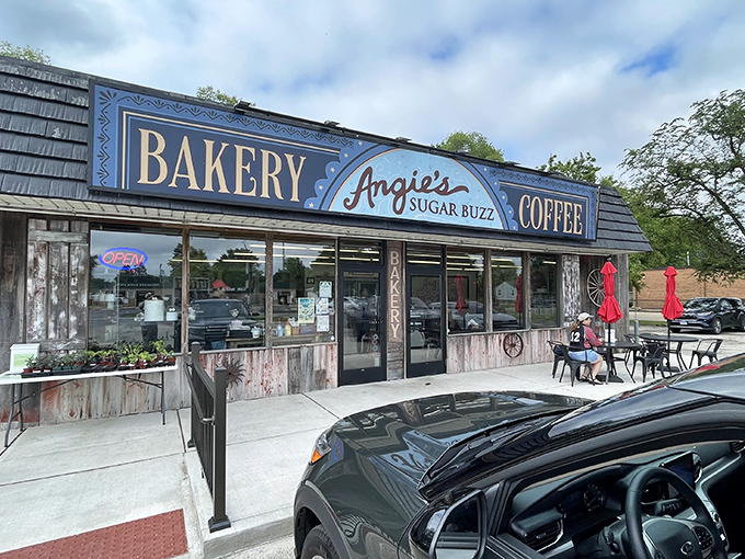 The charming storefront of Angie's Sugar Buzz Bakery beckons donut pilgrims with its nostalgic blue signage and inviting outdoor seating.