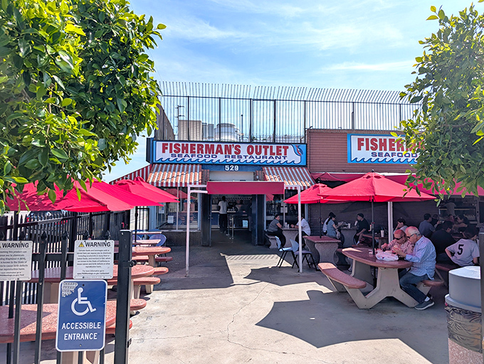 The bright red umbrellas at Fisherman's Outlet beckon like maritime flags signaling the presence of seafood treasure in downtown LA's industrial landscape.