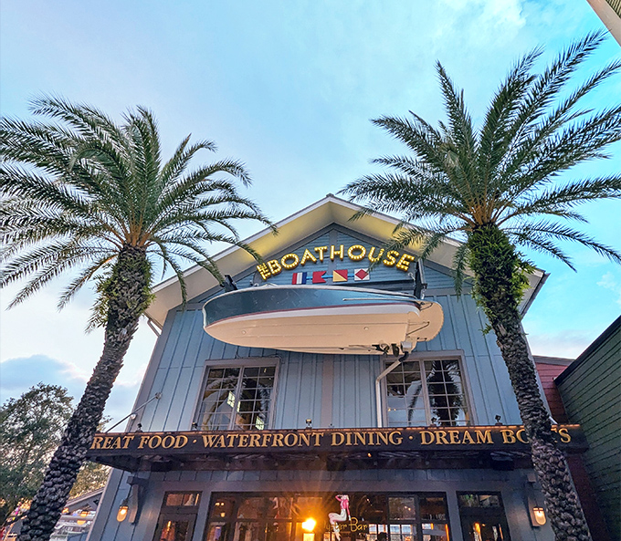 Swaying palms frame The Boathouse's nautical blue exterior, where "Great Food, Waterfront Dining, Dream Boats" promises Florida's ultimate seafood experience.