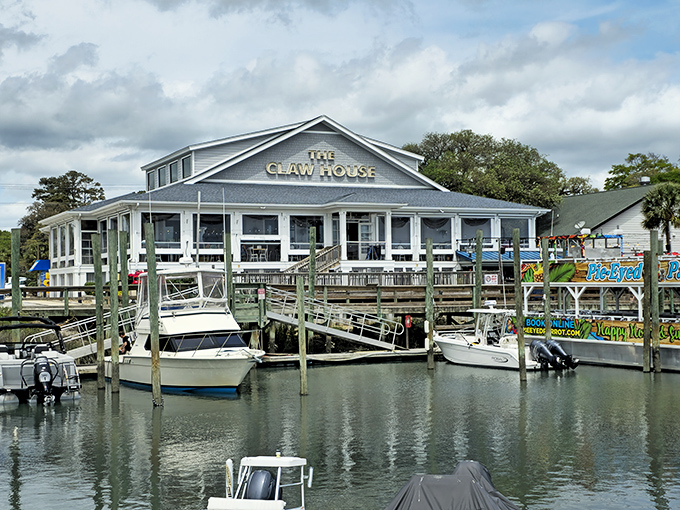 The Claw House stands proudly along Murrells Inlet's waterfront, a blue-gray beacon for seafood lovers with boats bobbing gently at its doorstep.