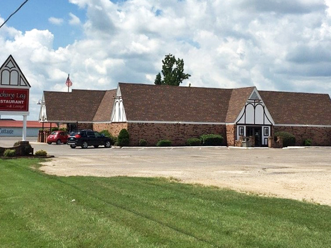 The distinctive A-frame architecture of Hickory Log Restaurant stands like a barbecue cathedral against the Missouri sky, beckoning hungry travelers with promises of smoky delights.