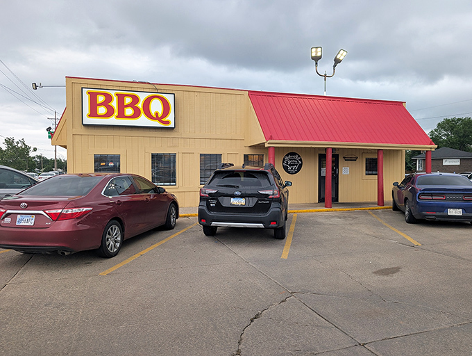 Don't let the modest appearance fool you – behind that tan exterior and bright red roof lies a temple of smoke where barbecue dreams come true daily.