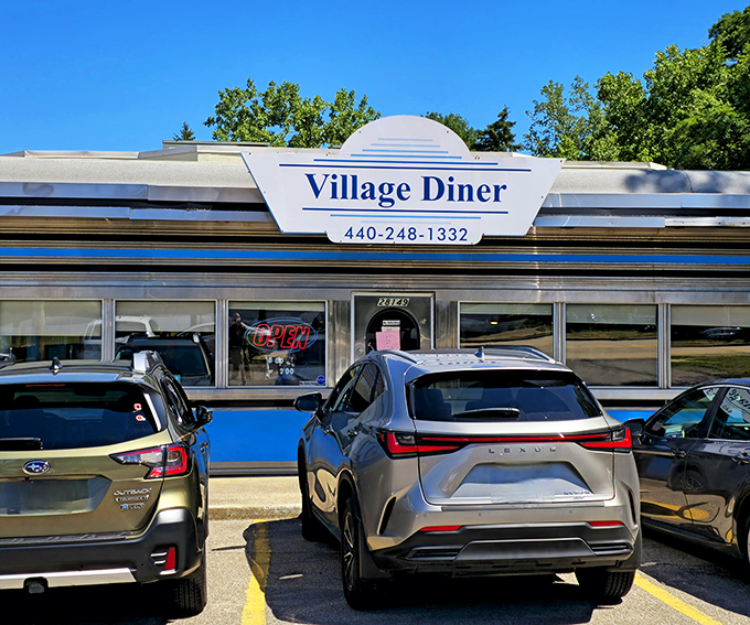 The classic chrome-and-blue exterior of Village Diner gleams like a time machine to the golden age of American breakfast. Pure roadside magic!