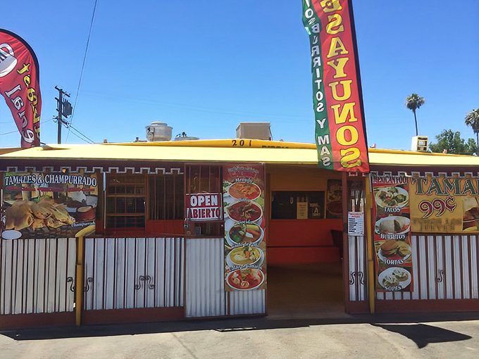 The vibrant yellow and burgundy exterior of Grandma's Tamales stands out like a beacon of culinary promise on East California Avenue in Bakersfield.